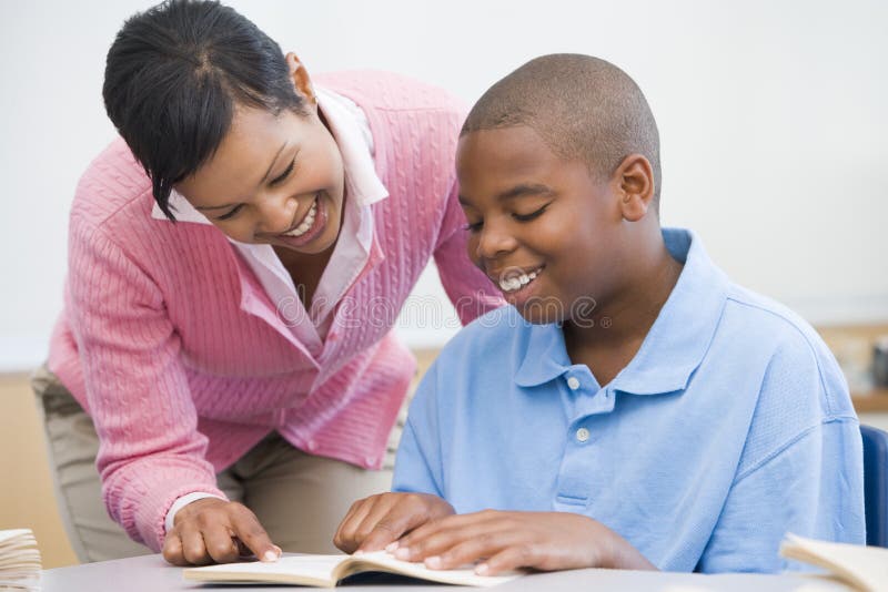 Elementary School Teacher Helping Pupil Stock Photo - Image of people ...