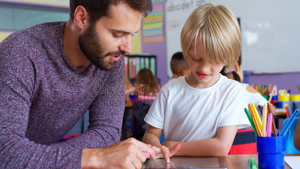 Elementary School Teacher and Male Pupil Drawing Using Digital Tablet ...