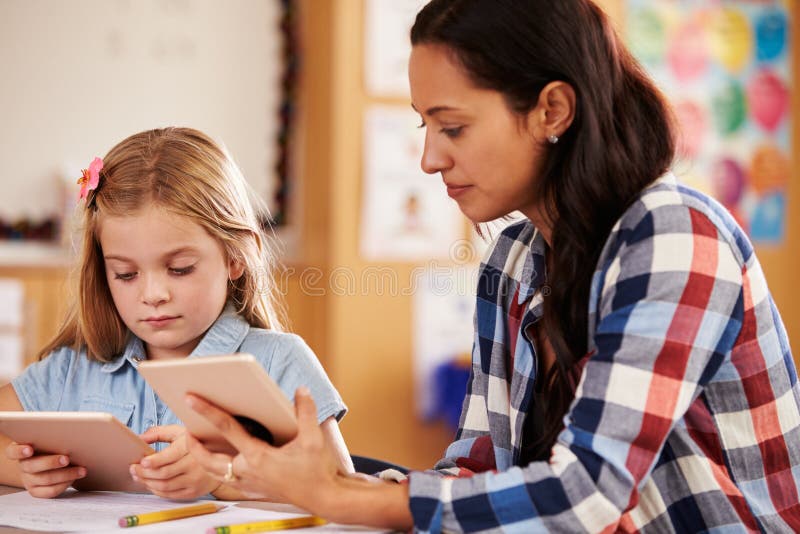 Elementary School Teacher And Pupil Using Tablet Computers - Stock ...