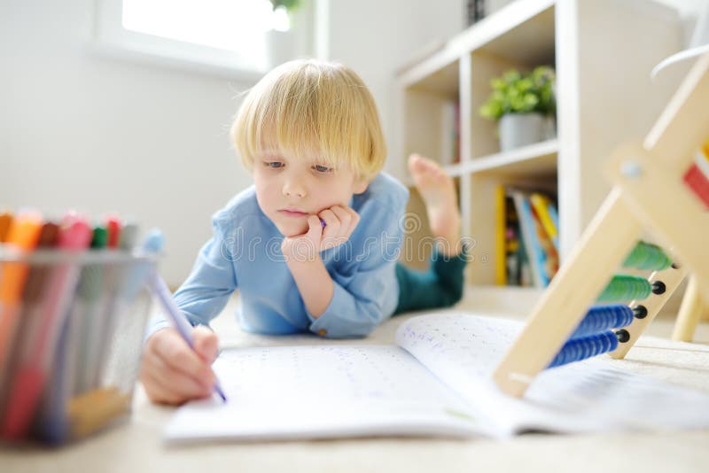 Elementary Student Boy Doing Homework on Floor at Home. Child Learning ...