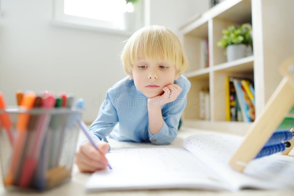 Elementary Student Boy Doing Homework on Floor at Home. Child Learning ...