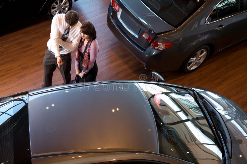 Elevated View Car Salesman Explaining Car Features To Customer Stock ... Elevated View Car Salesman Explaining Car Features To Customer Stock ...