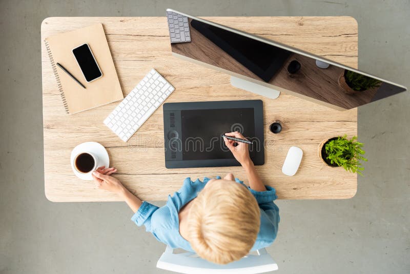 Elevated View of Female Teleworker Using Graphic Tablet at Table with ...