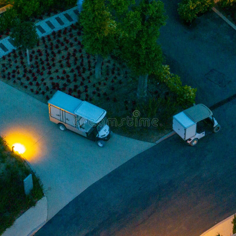 Aerial View Captures Two Compact Utility Vehicles Parked Near Lush ...
