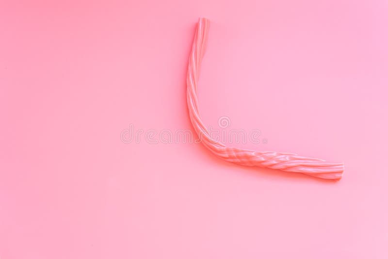 Elongated Pink Candy Isolated on a Flat Colored Background Stock Photo ...