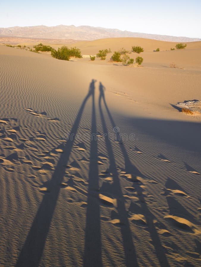 Elongated Shadow of Two People on Sand Stock Photo - Image of arid ...