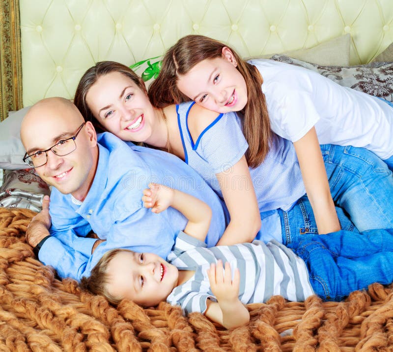 Eltern mit Kindern im Bett stockfoto. Bild von neigung - 102403054