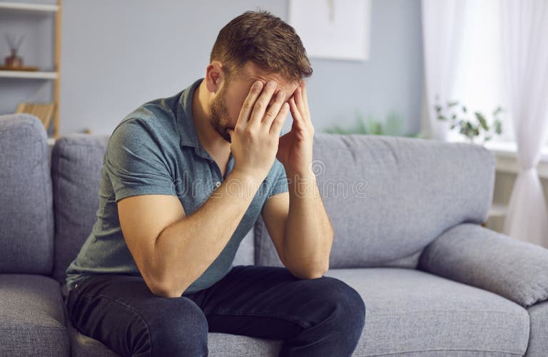 Distressed Man Sitting on a Couch, Thinking about Problems with His ...