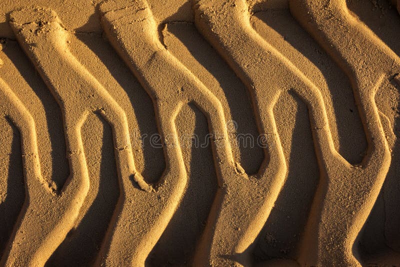Embossed Trail Excavator Tracks on the Wet Sand. Texture of Sand Stock ...