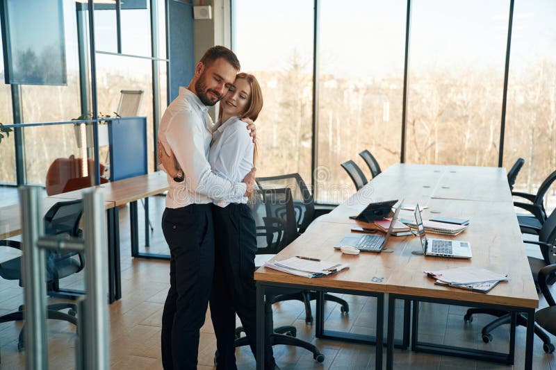 Embracing Each Other. Man and Woman Employees are Working in the Office ...