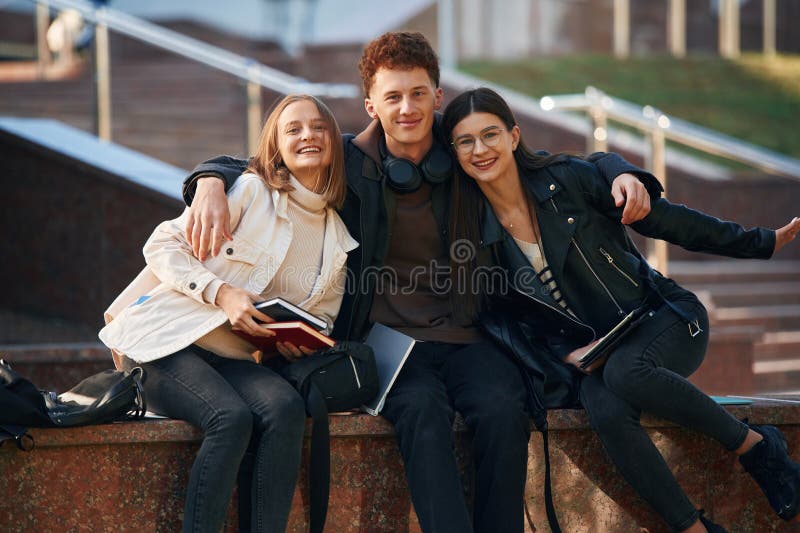 Embracing Each Other. Three Young Students are Outside the University ...