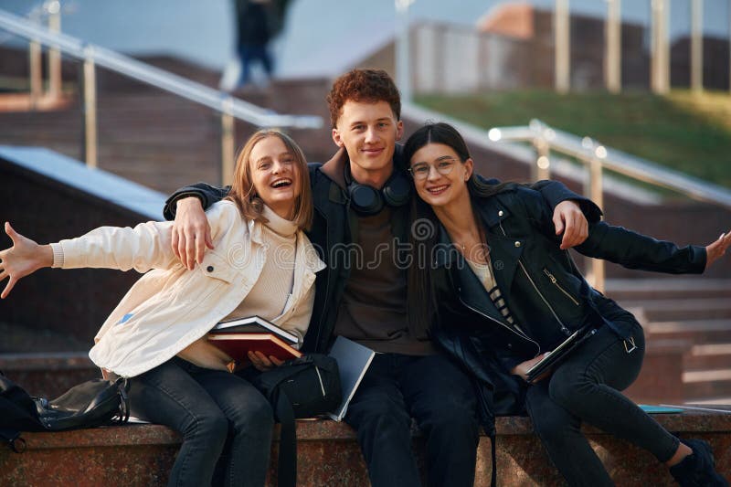 Embracing Each Other. Three Young Students are Outside the University ...