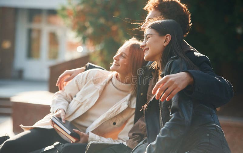 Embracing Each Other. Three Young Students are Outside the University ...
