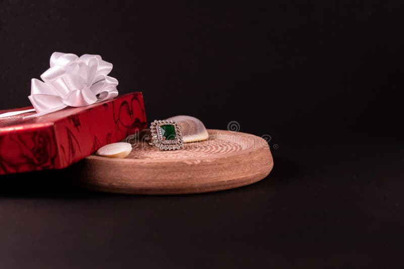 Emerald Ring with Seashells and Decorated Red Gift Box on Sand Stone ...
