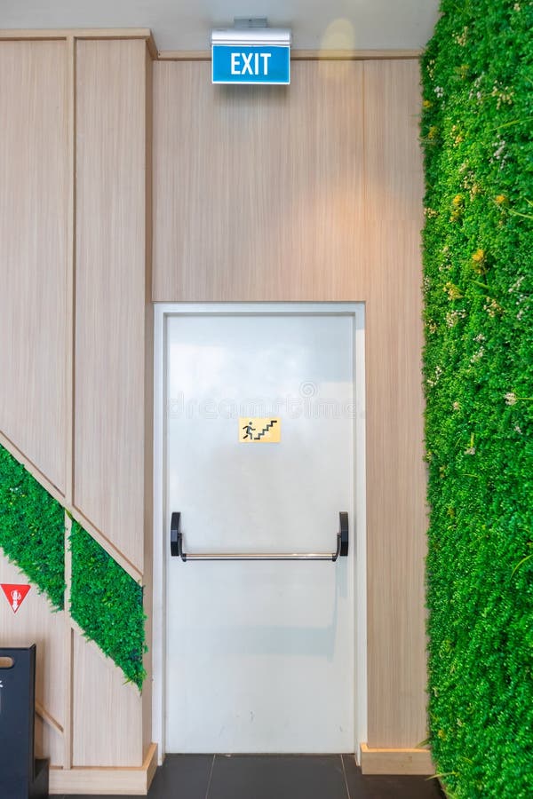 An Emergency Exit Door and Fire Extinguisher on the Floor in a Room ...