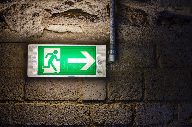 Emergency Exit Light Green Sign on Brick Wall in the Dark Stock Photo ...