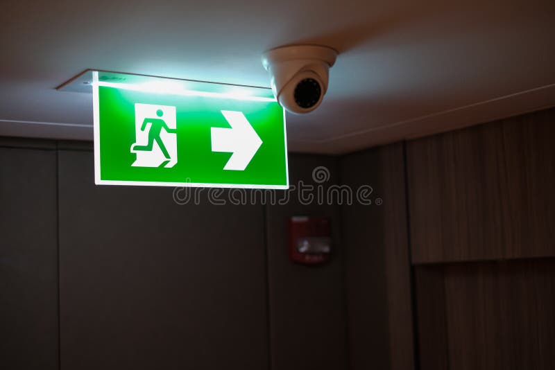Emergency Exit Sign at the Corridor in Building. Green Fire Exit Sign ...