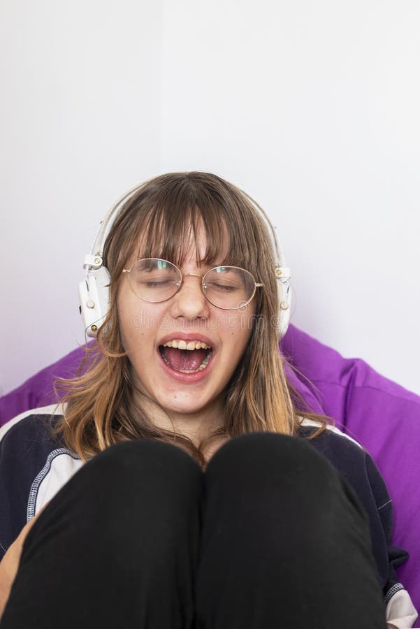 Emotional Teenage Girl In Glasses In Headphones And Gadgets Screams