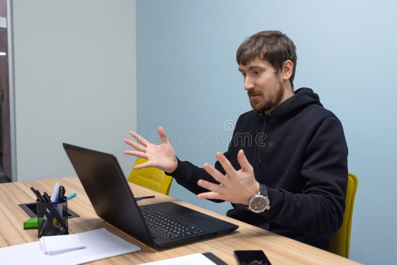 Emotional Young Man Working in the Office on a Laptop. Frustrated Man ...
