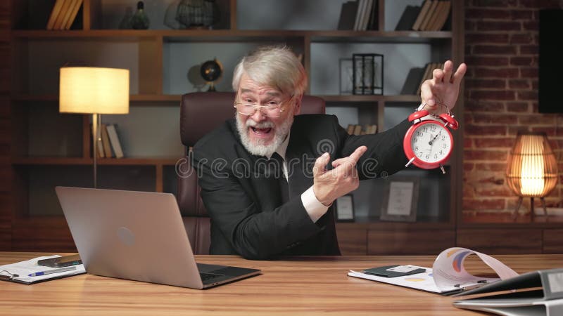 Employee Holding Alarm Clock Above Office Desk with Gadgets Stock ...