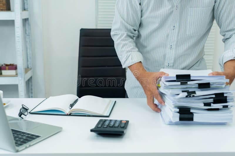 Employee Manages a Stack of Documents at a Busy Office Desk, Using ...