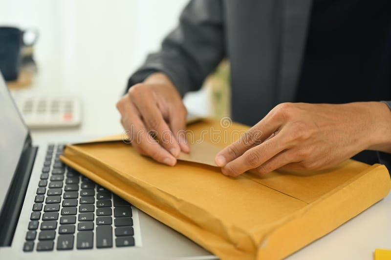 Employee Sealing a Brown Envelope for Shipment at Desk Stock Image ...