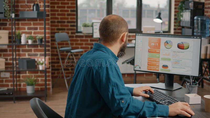 Employee Using Computer and Documents To Work on Business Stock Photo ...