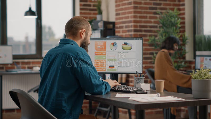 Employee Working with Rate Data Charts on Computer at Desk Stock Photo ...