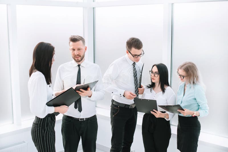 Employees Discuss Business Documents Standing in the Office Hall. Stock ...