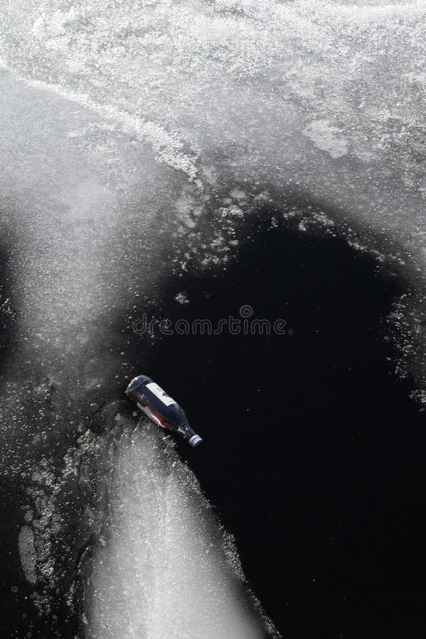 Empty Alcohol Bottle Floating in the Water at Wintertime Stock Image ...