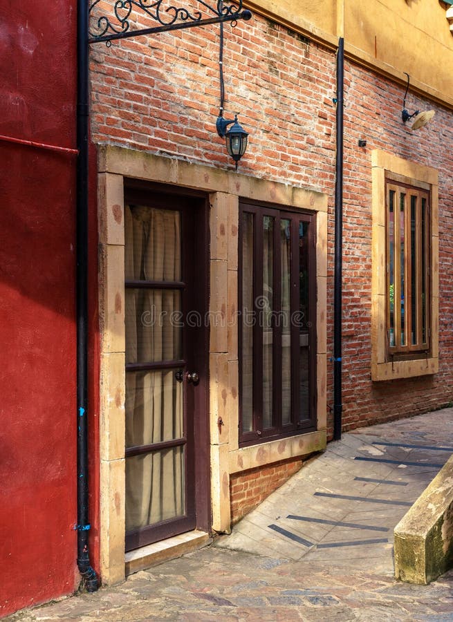 Empty Alleyway with Windows and Door on Brick Wall Stock Photo - Image ...