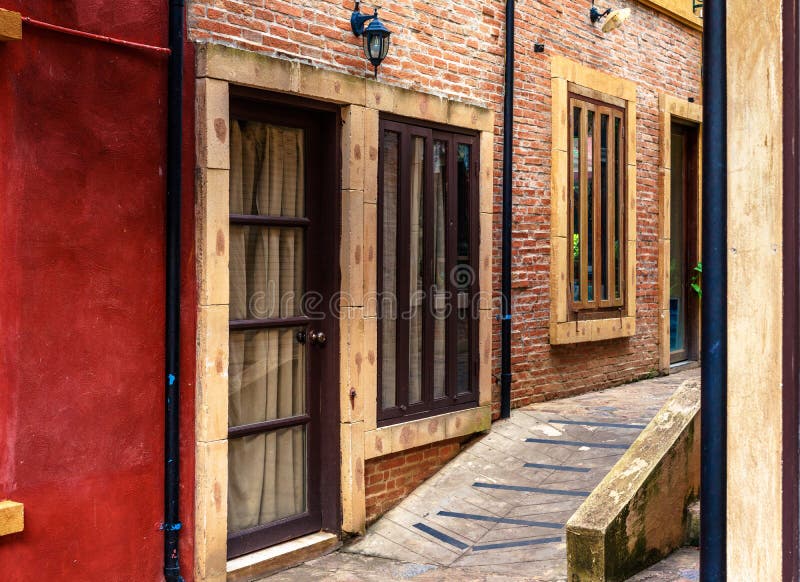 Empty Alleyway with Windows and Doors on Brick Wall Stock Photo - Image ...