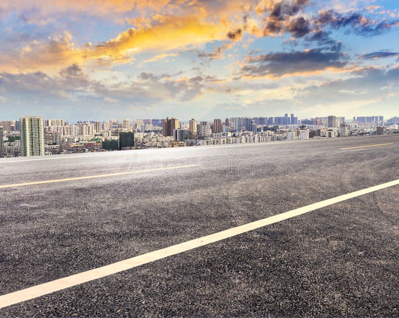 Empty Asphalt Highway and City Landmark Buildings Under Evening Light ... Empty Asphalt Highway and City Landmark Buildings Under Evening Light ...