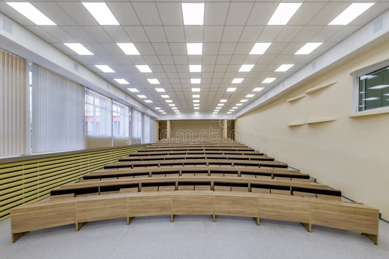 Empty Auditorium with Tiered Wooden Seating and a Bright Ceiling ...