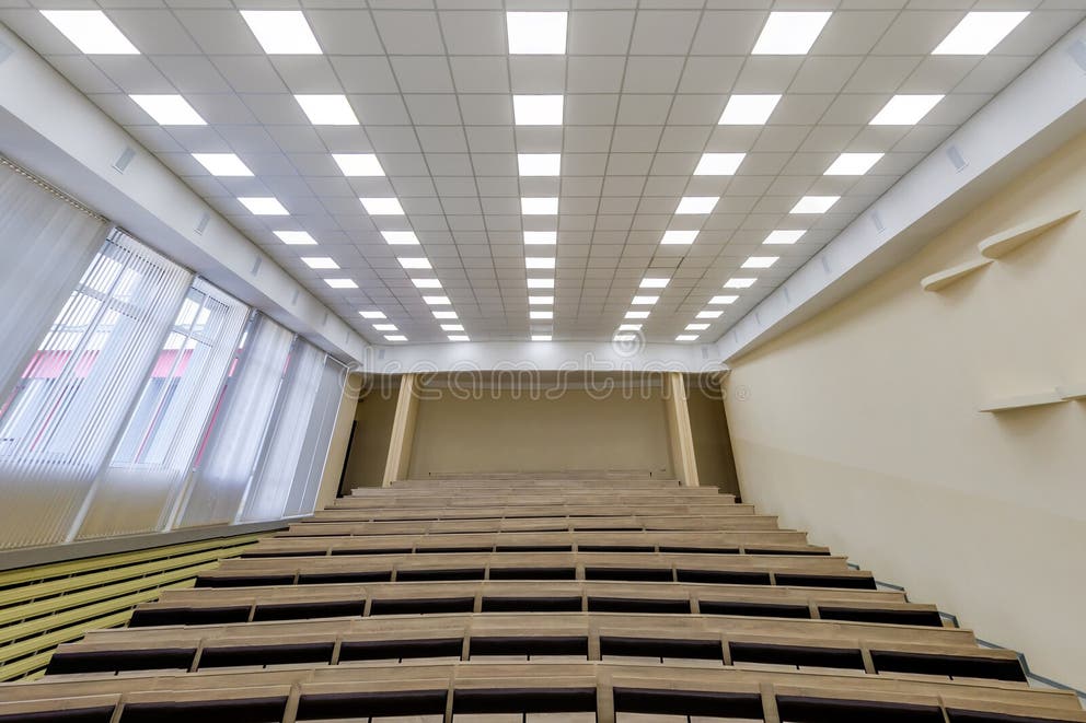 Empty Auditorium with Tiered Wooden Seating and a Bright Ceiling ...