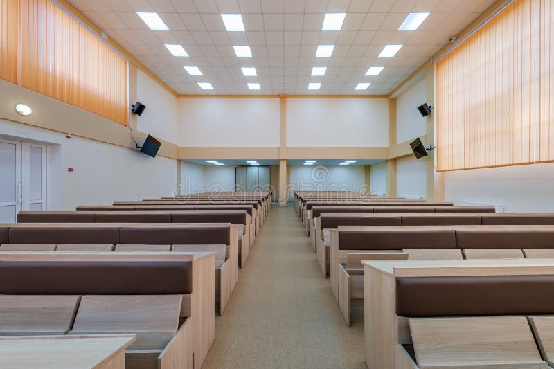 Empty Auditorium with Tiered Wooden Seating and a Bright Ceiling ...