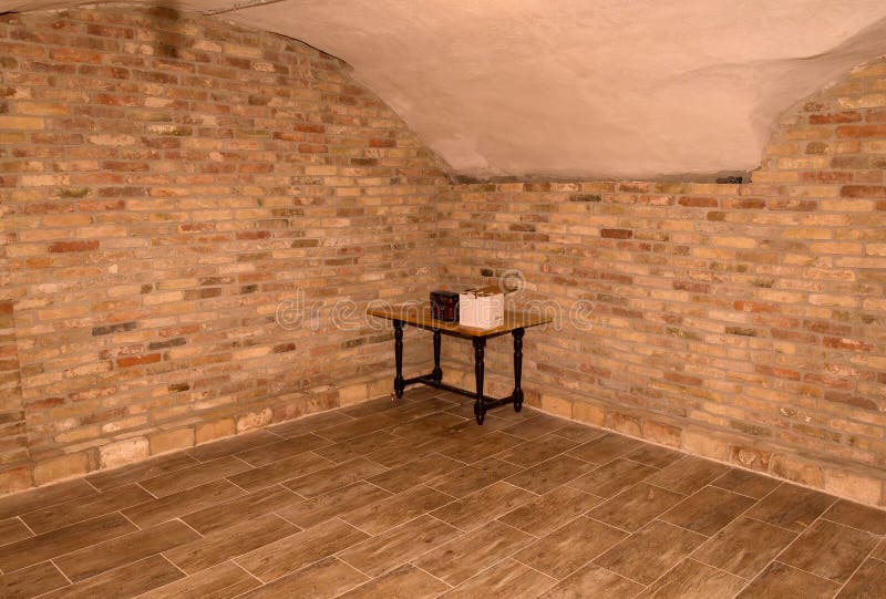 Empty Basement Room with Exposed Brick Walls and Tiled Floor Featuring ...