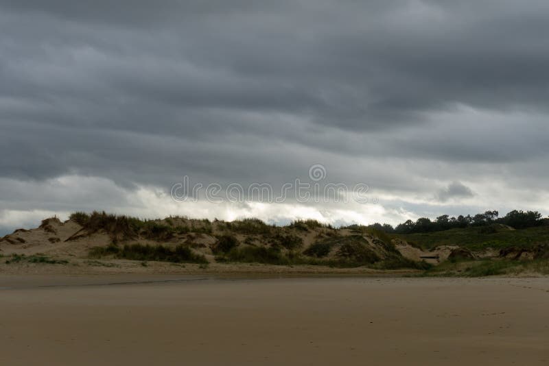 Empty Beach with Tall Sand Dunes Under an Overcast Sky Stock Photo ...