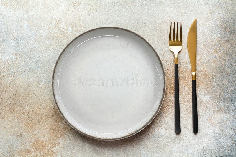 Empty Beige Plate, Knife and Fork on a Brown Background. Cutlery, Top ...
