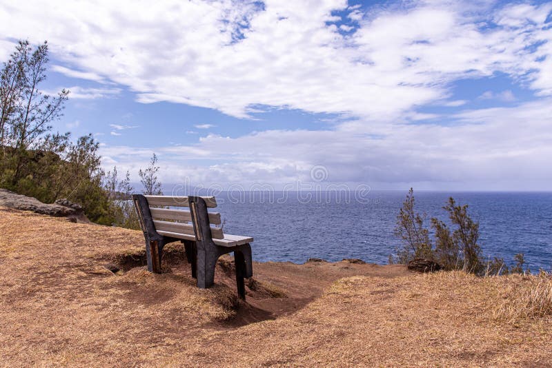 An Empty Bench on the Edge of a Cliff Overlooking Ocean Stock Photo ...