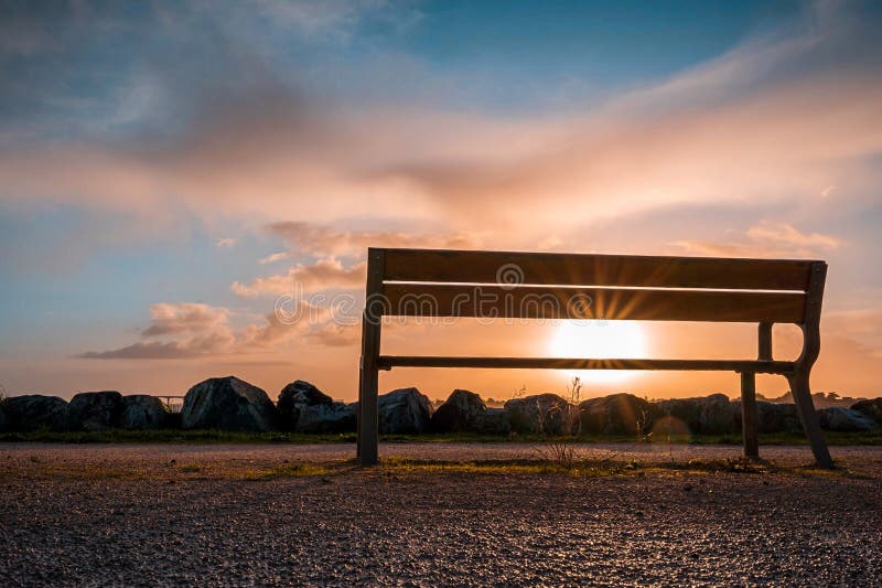 Empty Bench at Sunrise with Sun Rays Across it. Tranquility Concept ...
