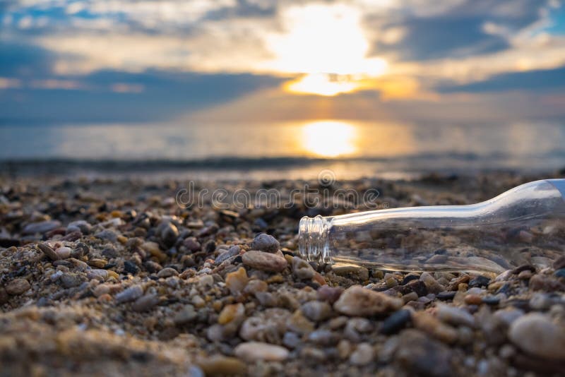 Empty Bier Bottle Laying on the Pebble Beach with Sunset Sky in the ...
