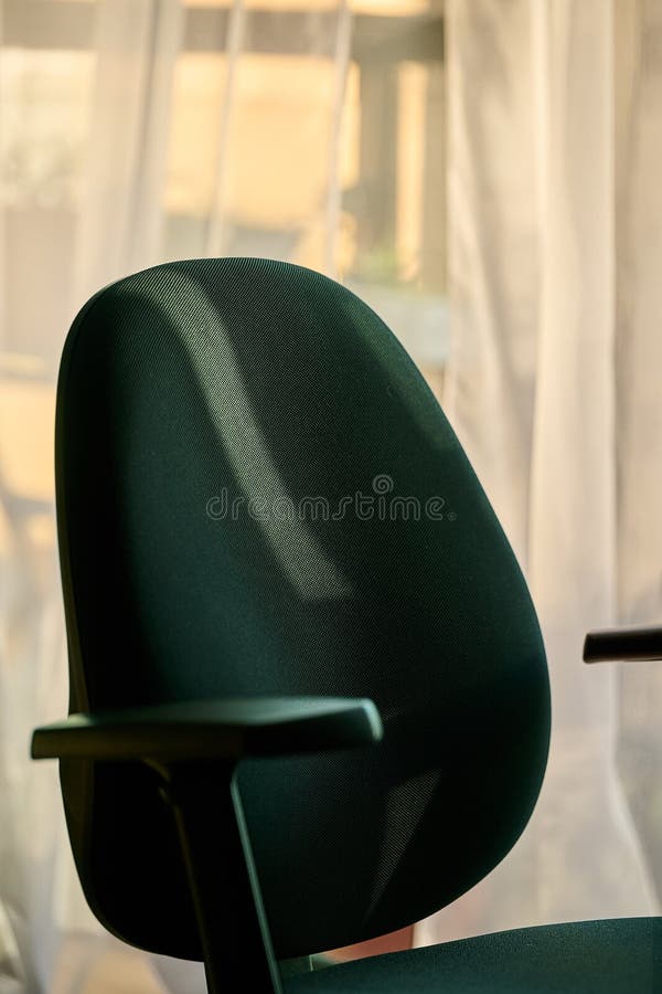 Empty Black Office Chair with Armrest with Sunlight Falling Across the ...