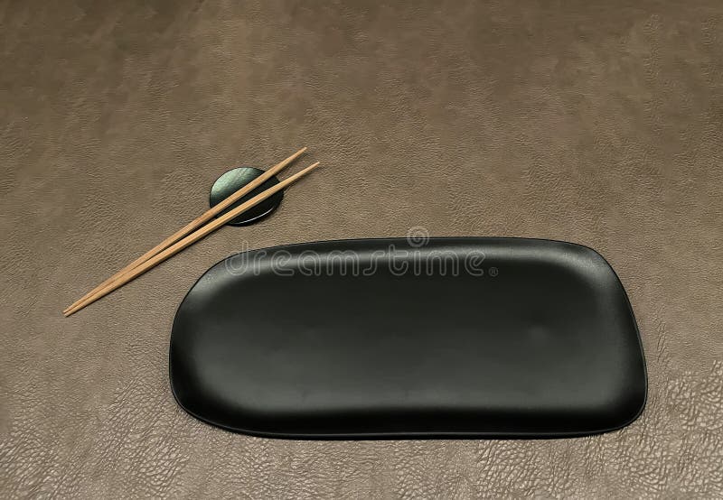 An Empty Black Sushi Plate on a Brown Table with Leather Texture, Next ...