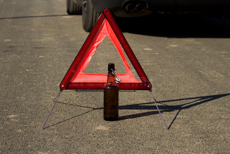 An Empty Bottle of Beer or Other Alcohol and a Warning Triangle. Stock ...