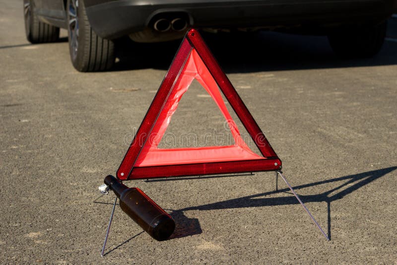 An Empty Bottle of Beer or Other Alcohol and a Warning Triangle. Stock ...