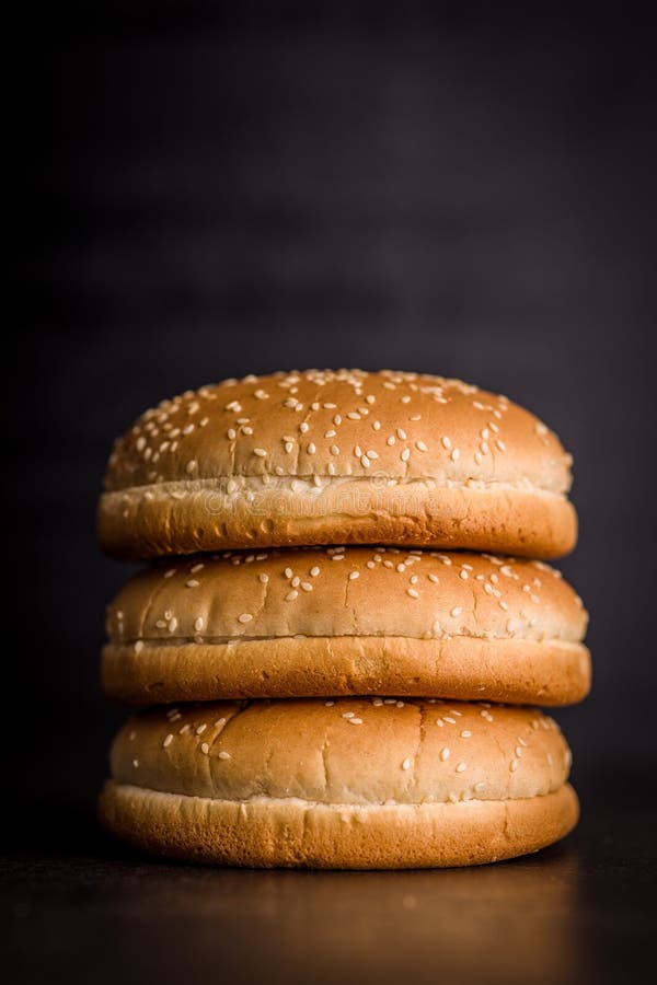 Empty Burger Bun with Sesame Seeds on Black Table Stock Image - Image ...