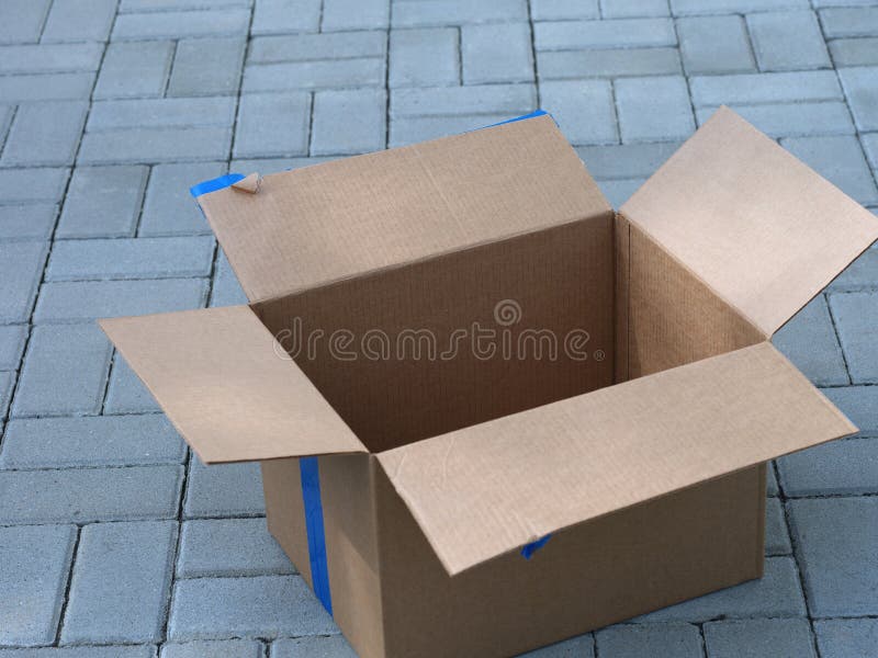 An Empty Cardboard Box Lying on Tiles Outside Stock Photo - Image of ...