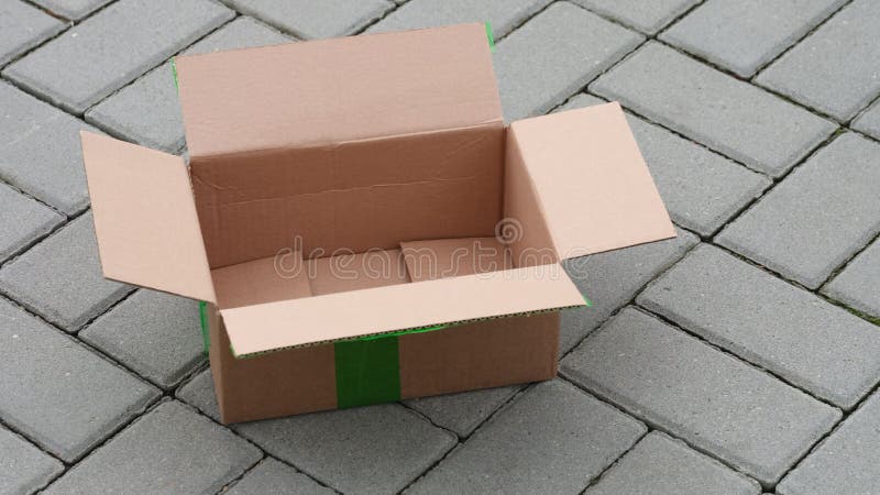 An Empty Cardboard Box Lying on Tiles Outside. Stock Footage - Video of ...
