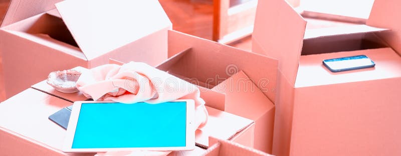 Empty Cardboard Boxes Ready To Be Open Along with a Tablet with Green ...